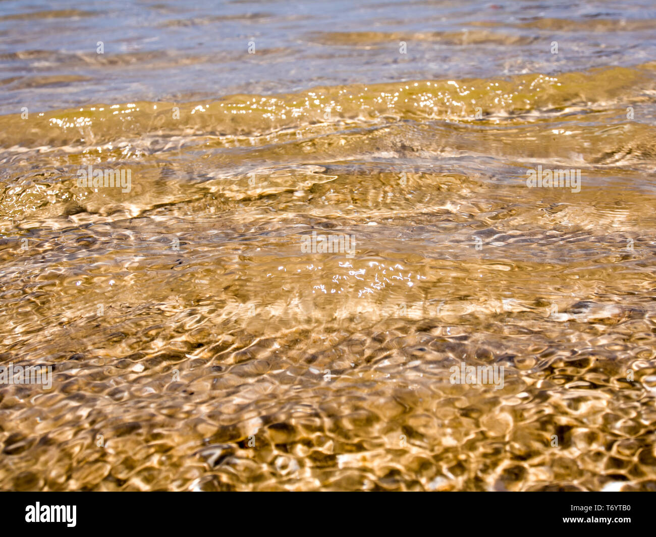 Light reflection on the surface of movement sea on sand beach Stock ...