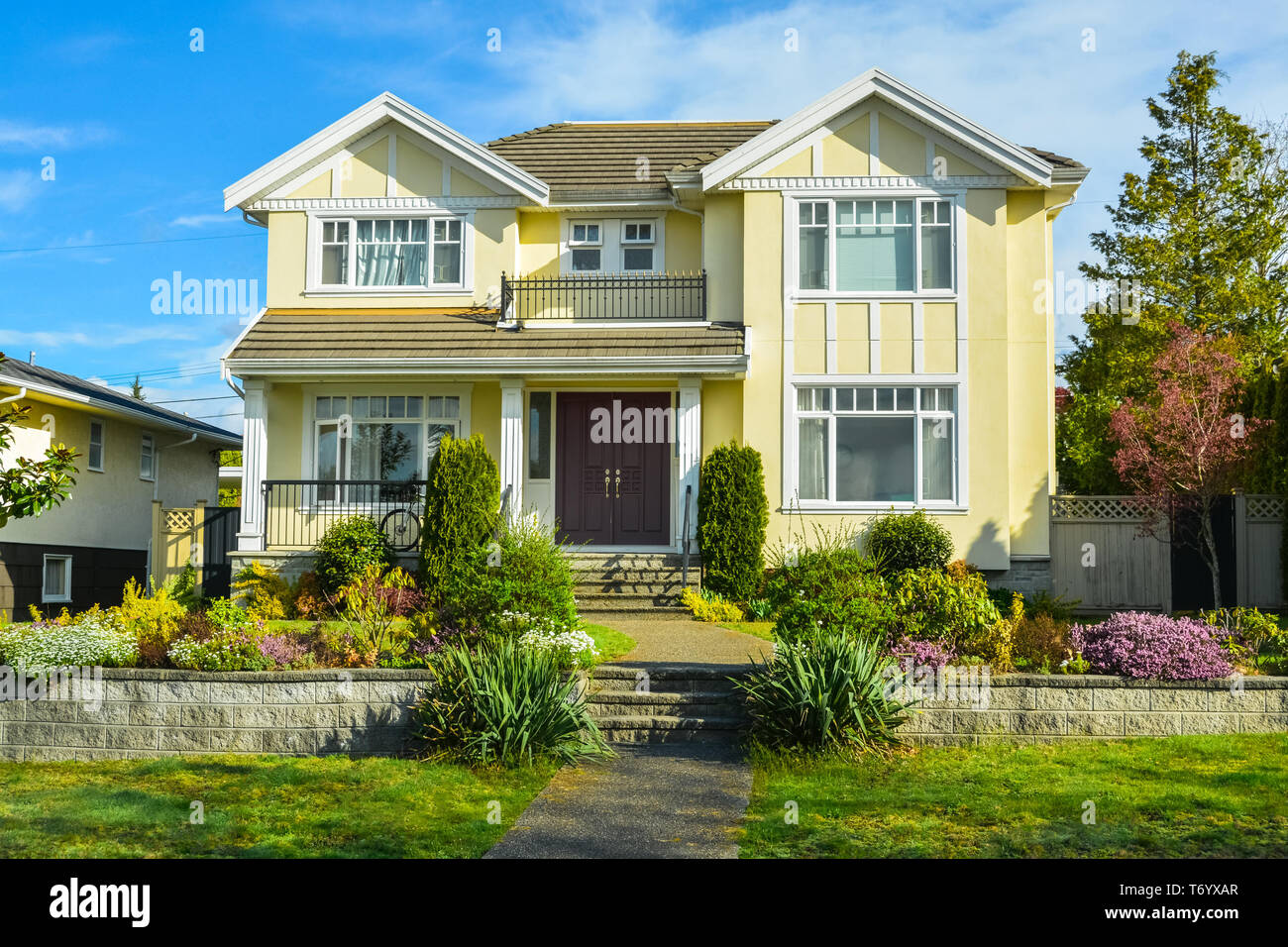 Big family house with landscaped front yard terrace on blue sky ...