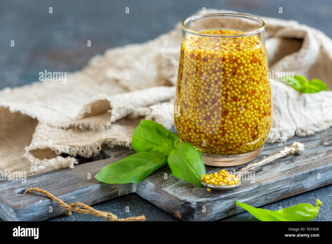 Mustard sauce in a glass jar and fresh basil Stock Photo - Alamy