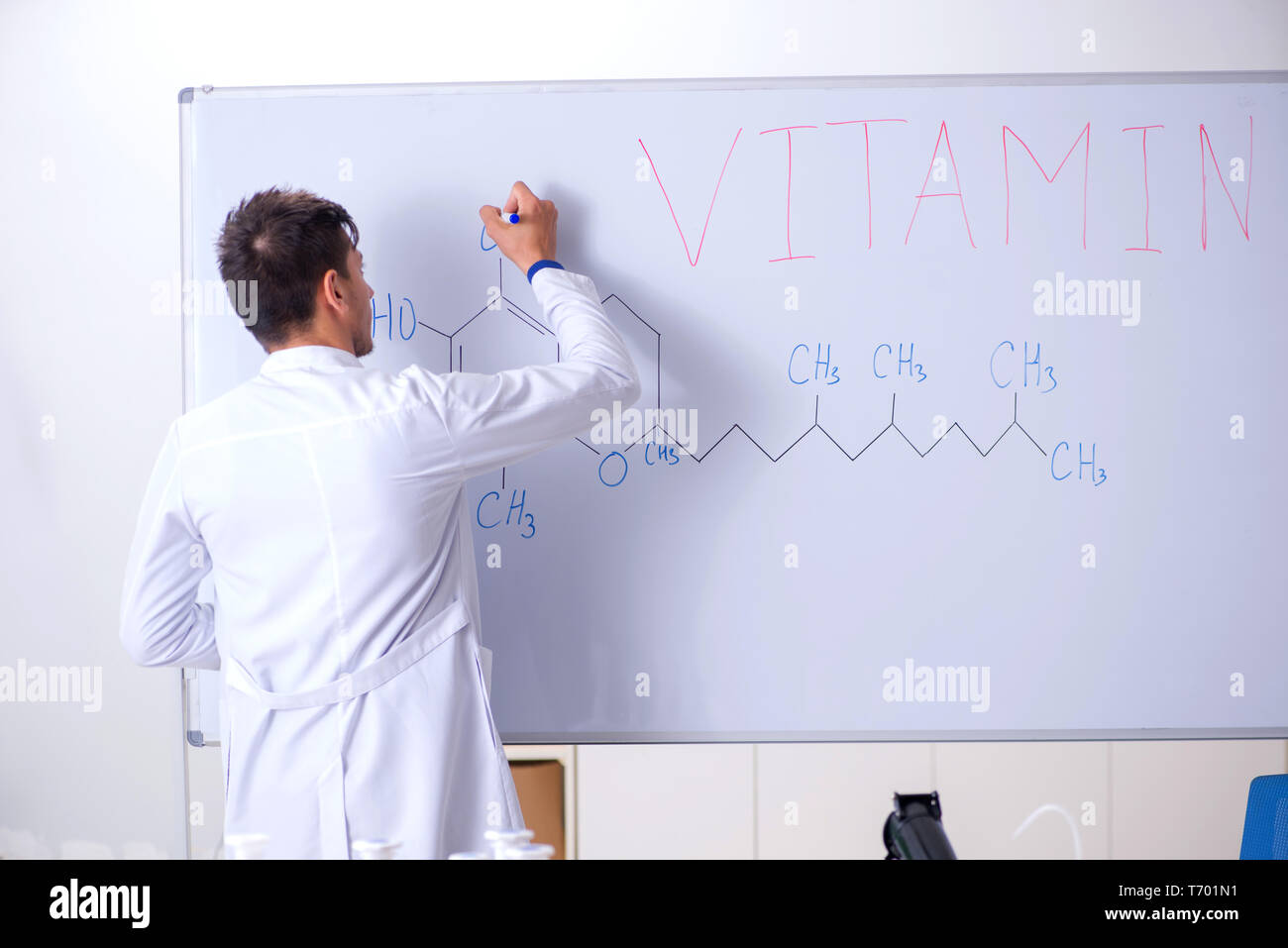 Young chemist standing in front of the whiteboard Stock Photo - Alamy