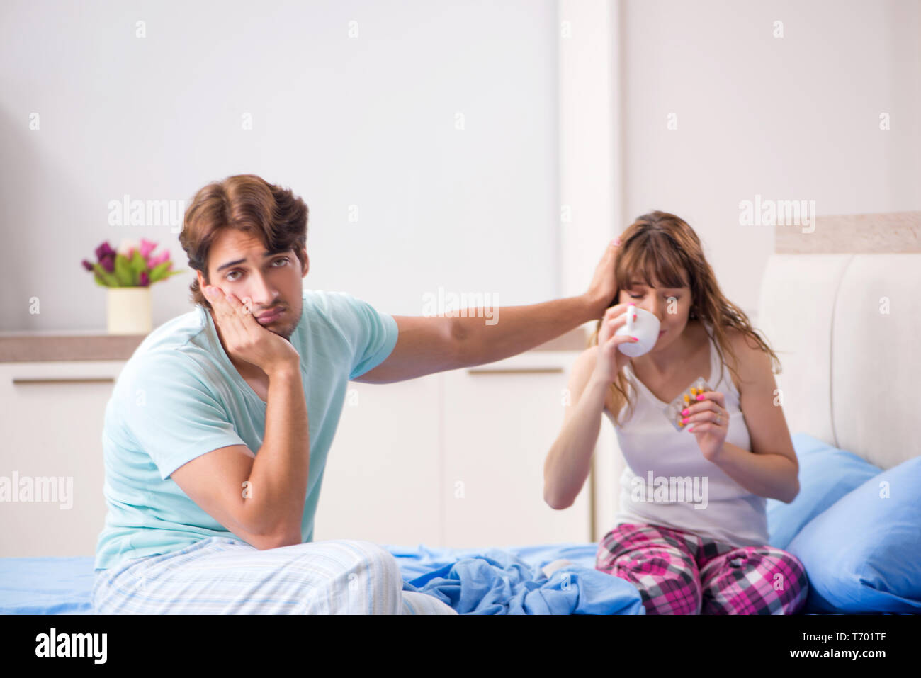 Young husband looking after sick wife in the bedroom Stock Photo - Alamy