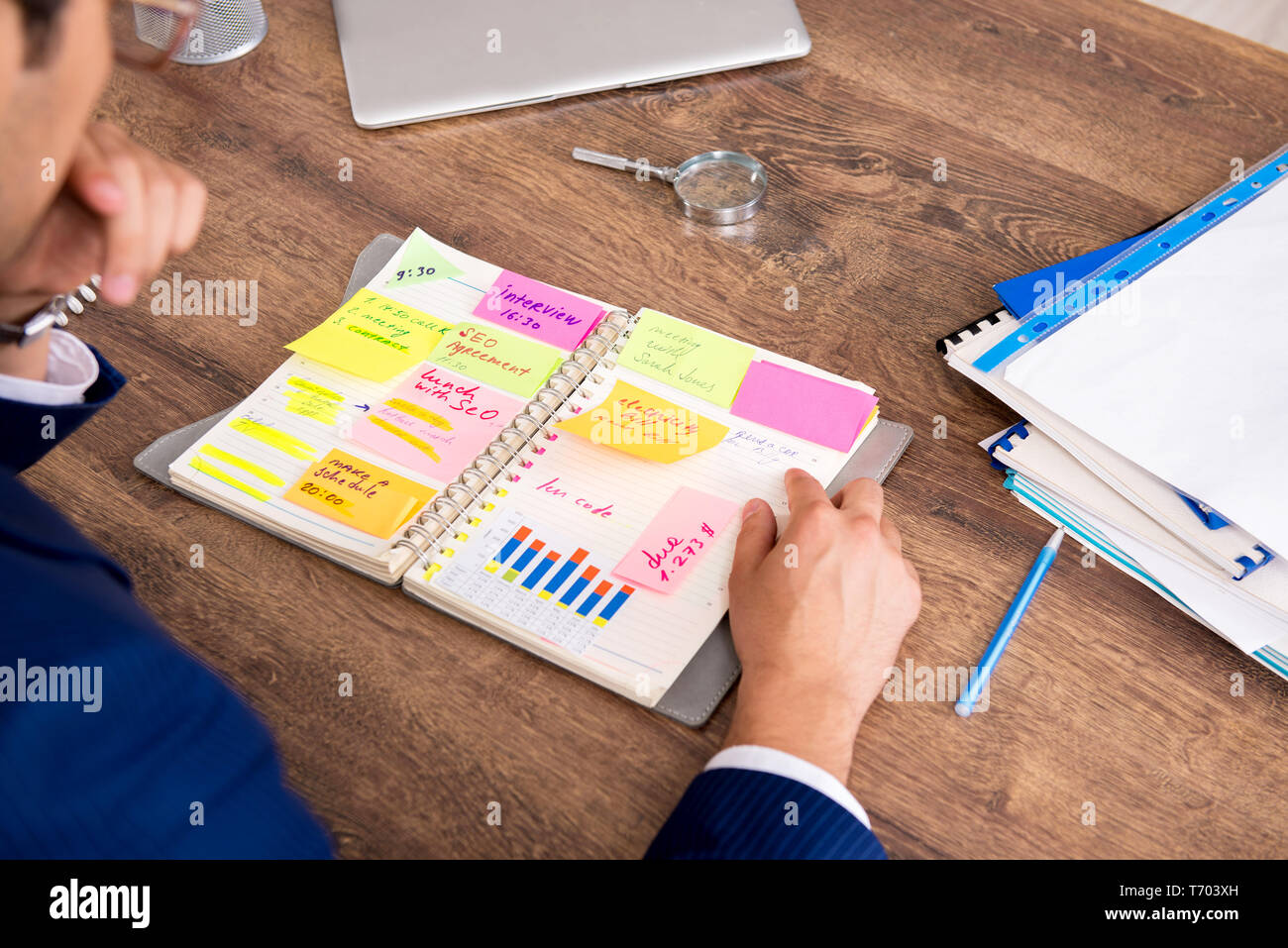 Young handsome employee planning his work activity Stock Photo - Alamy
