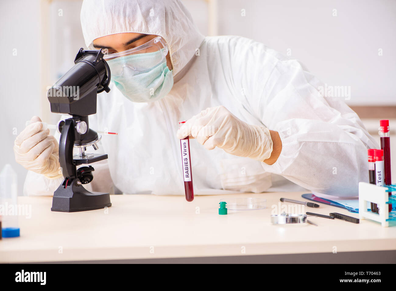 Young handsome lab assistant testing blood samples in hospital Stock ...