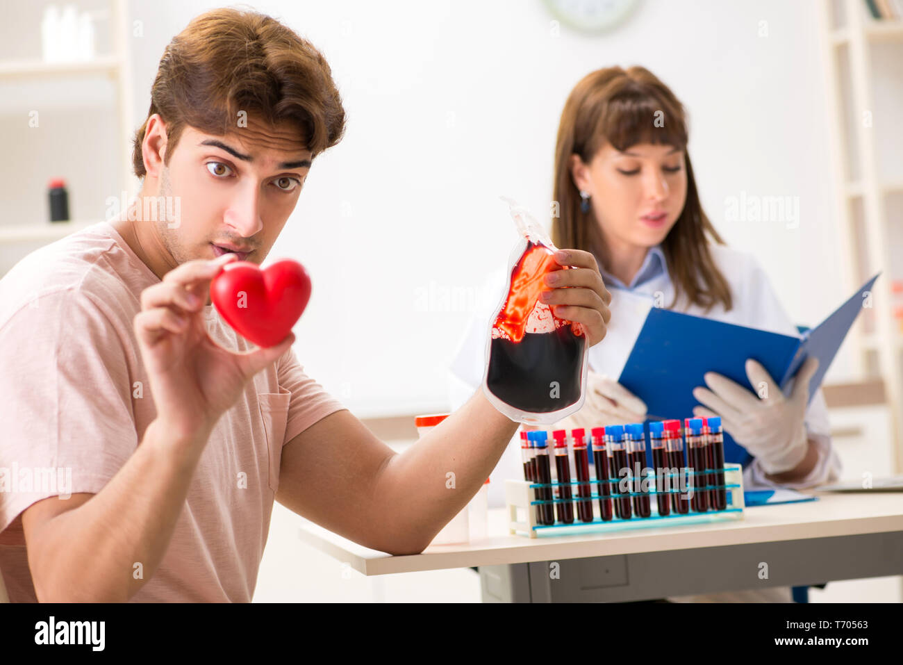 Man giving his blood as a donor Stock Photo - Alamy