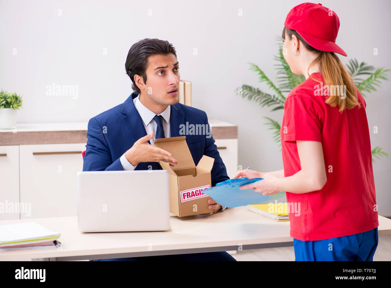 The courier delivering parcel to the office Stock Photo - Alamy