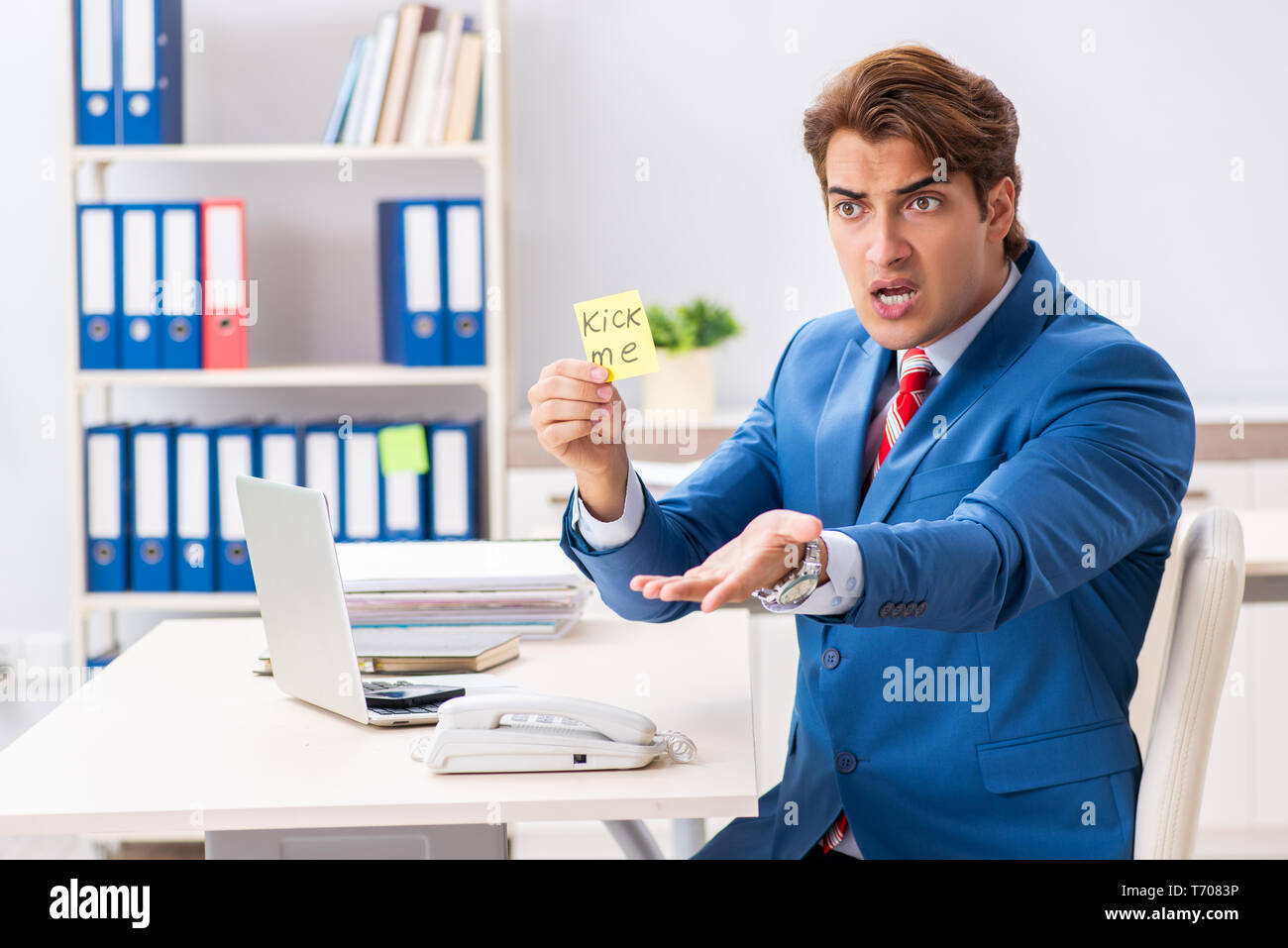 The office prank with kick me message on sticky note Stock Photo - Alamy