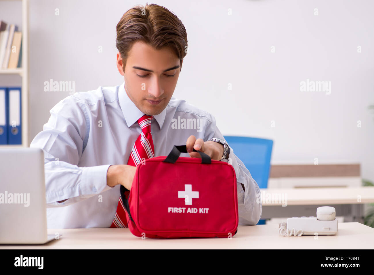 The man with first aid kit in the office Stock Photo - Alamy