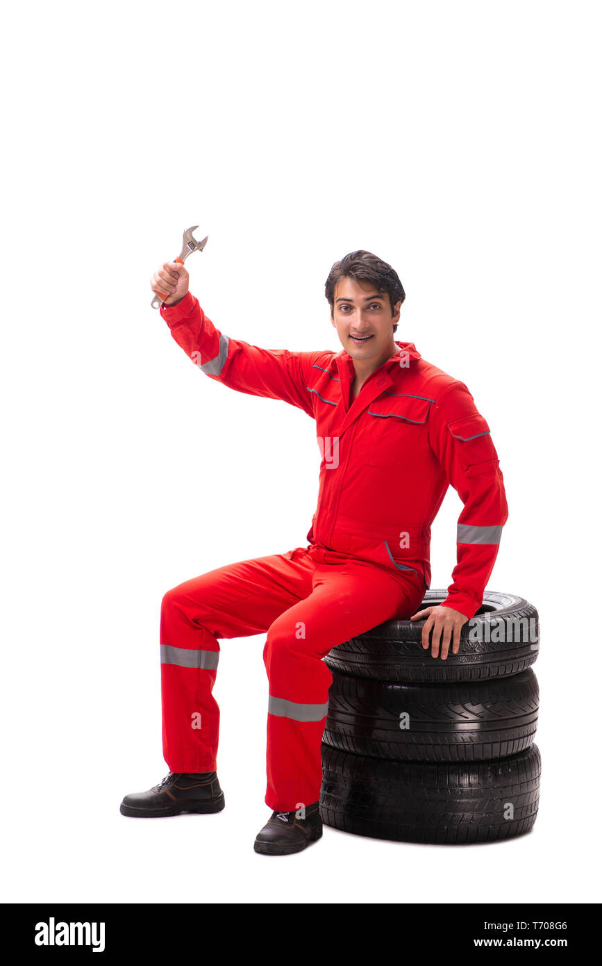 The young garage worker with tyre isolated on white Stock Photo - Alamy
