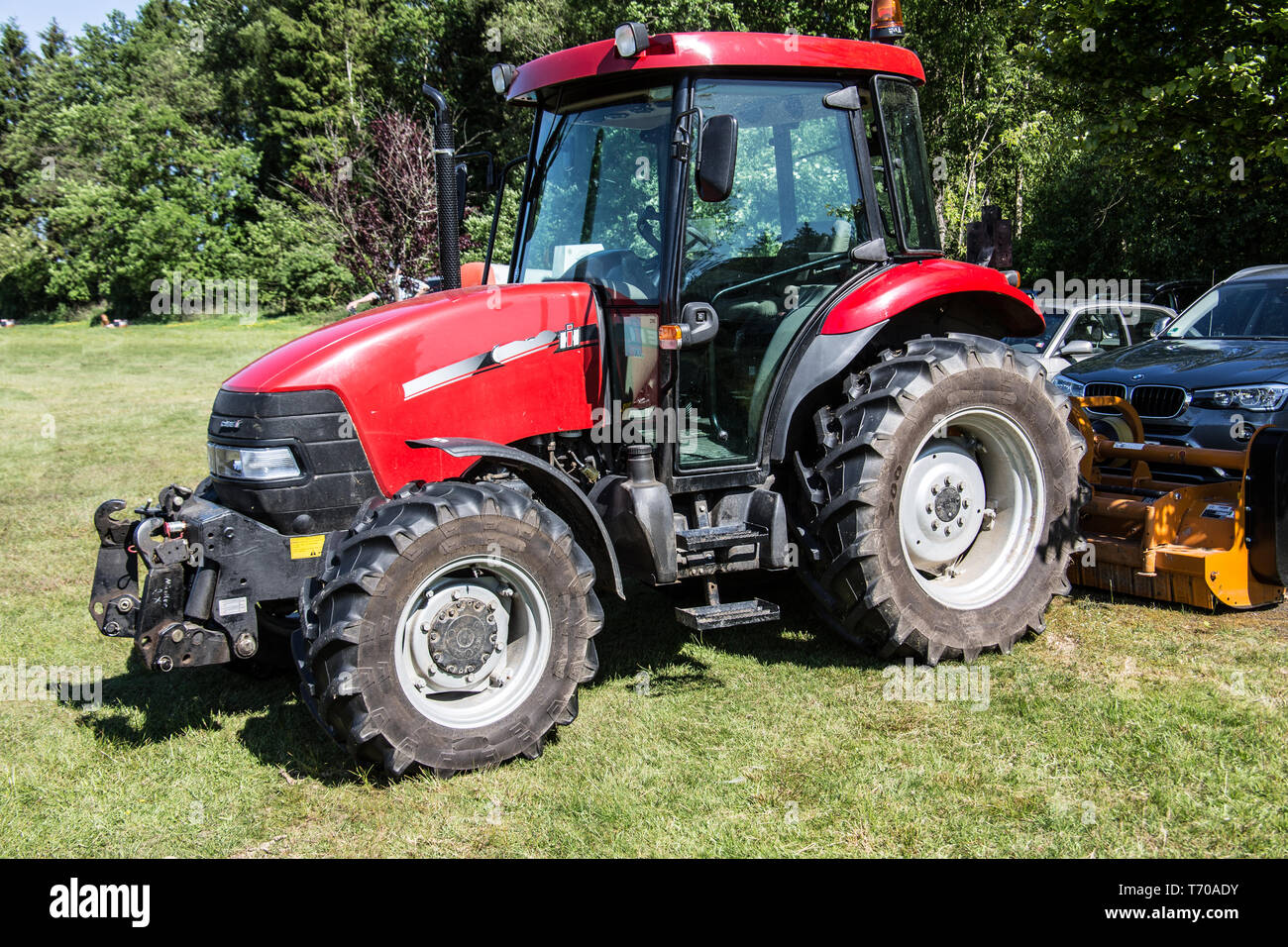 Red tractor on meadow Stock Photo - Alamy