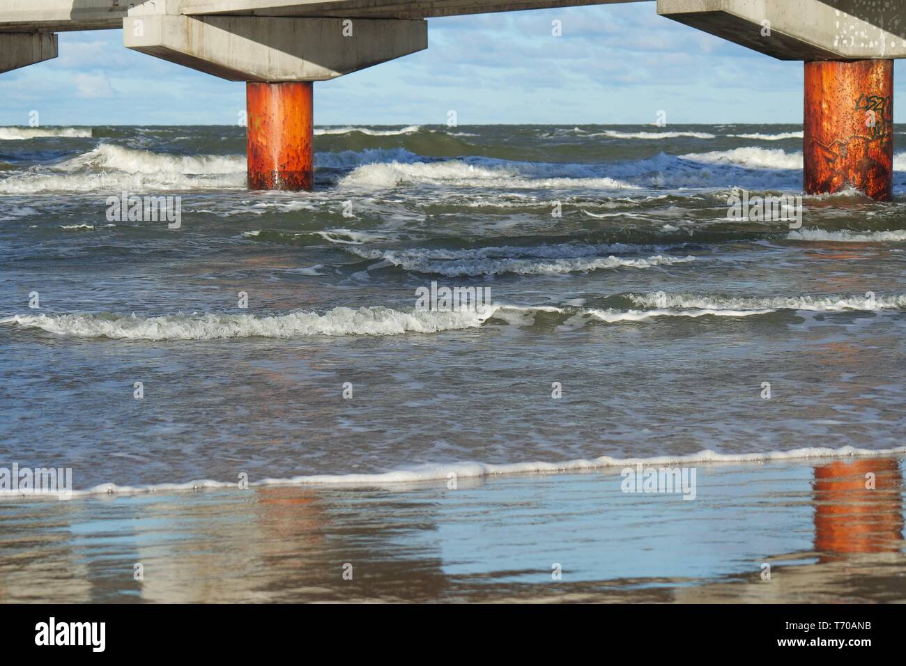 Sea under the pier Stock Photo - Alamy