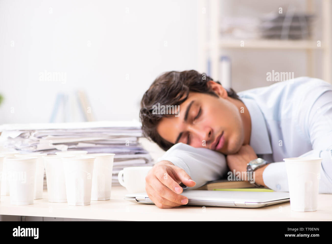 Young employee addicted to coffee Stock Photo - Alamy