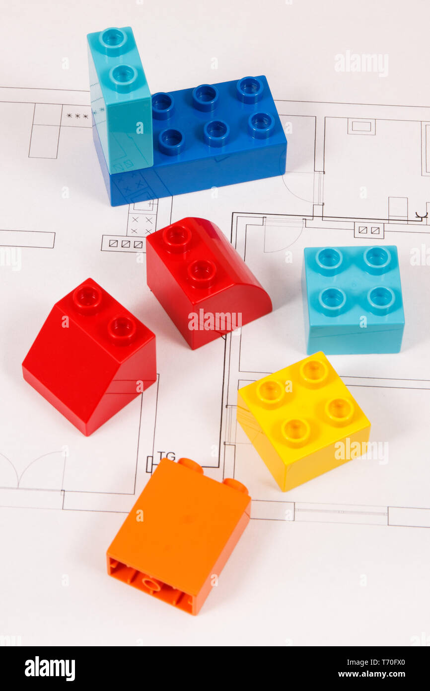 Colorful plastic toy blocks and construction housing plan. Concept of ...