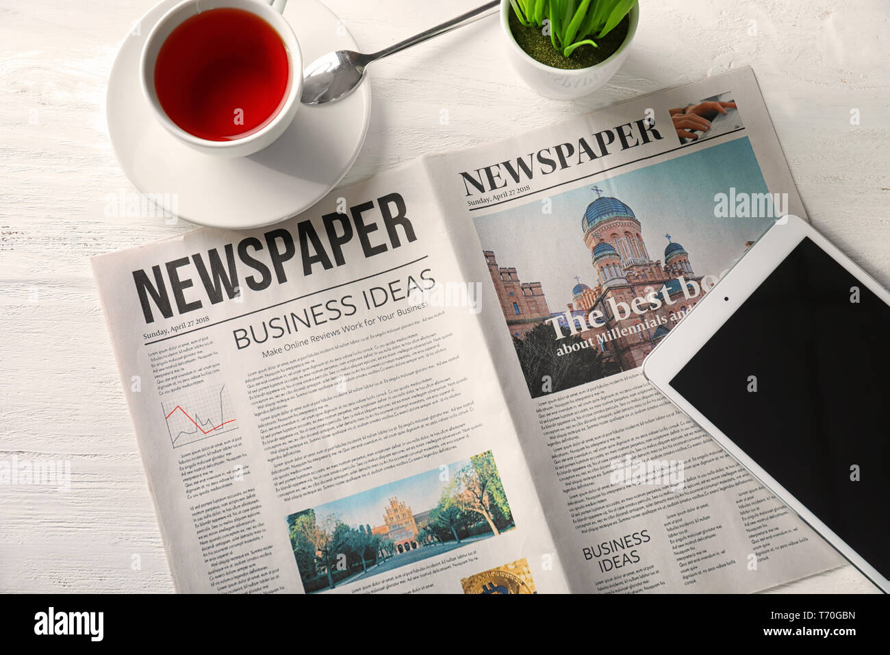 Newspaper with cup of tea and tablet computer on table Stock Photo - Alamy
