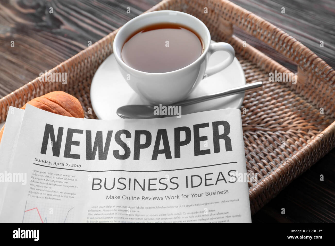 Tray with newspaper and cup of tea on wooden background Stock Photo - Alamy