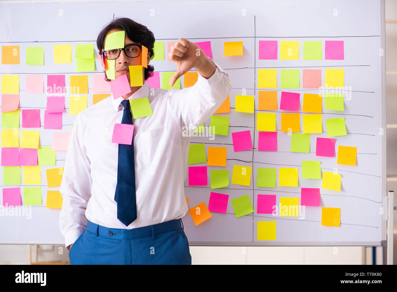 Young employee in conflicting priorities concept Stock Photo - Alamy