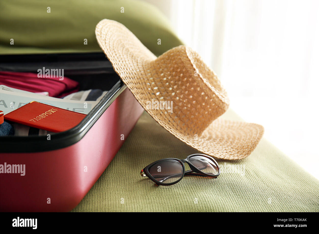 Open suitcase with packed things on bed Stock Photo - Alamy
