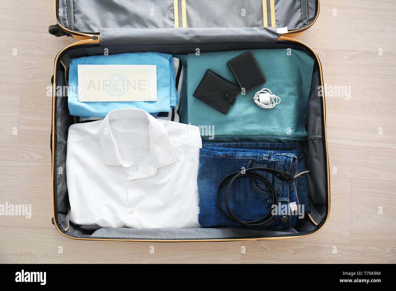 Open suitcase with packed things on floor, top view Stock Photo - Alamy