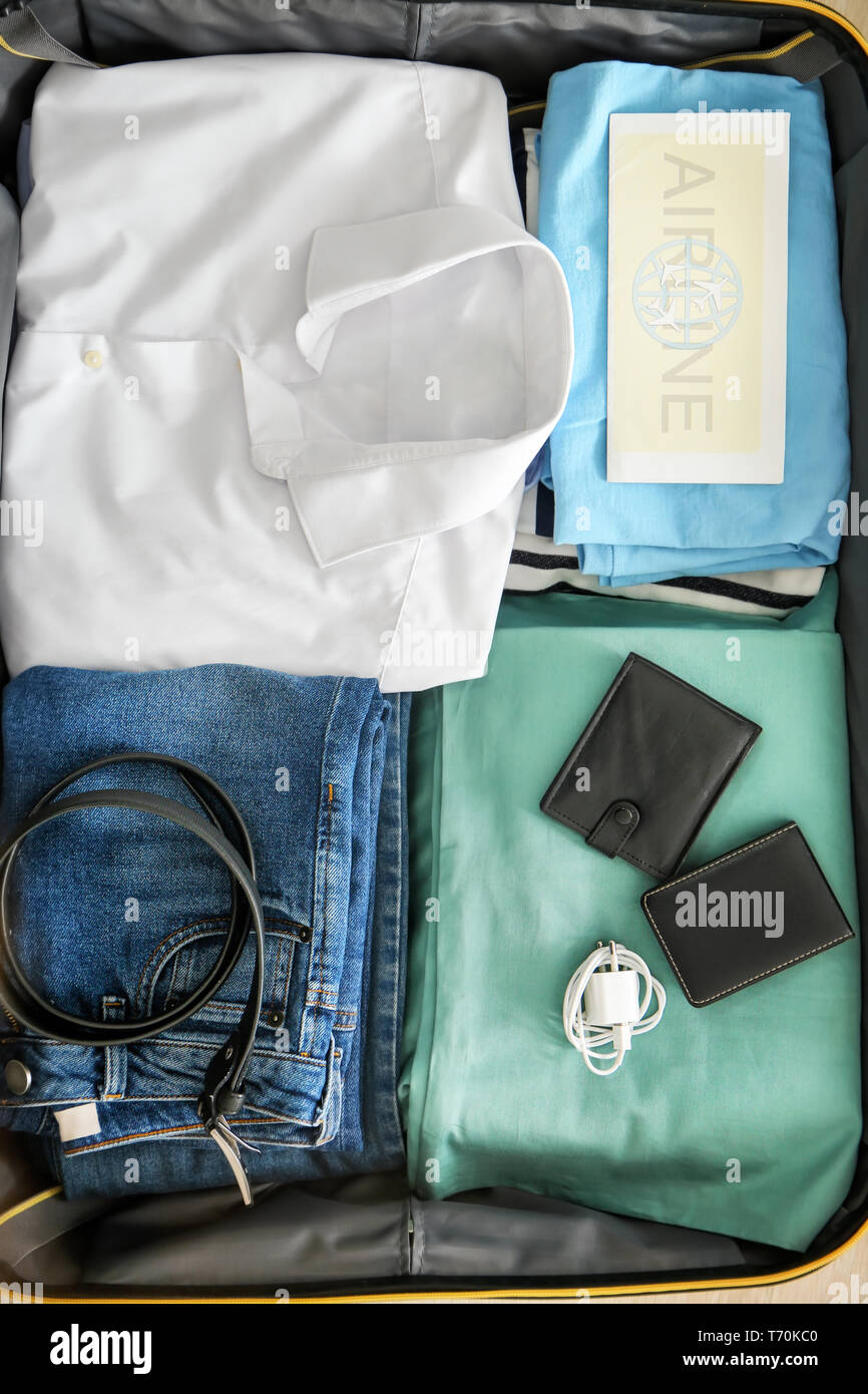 Open suitcase with packed things, top view Stock Photo - Alamy