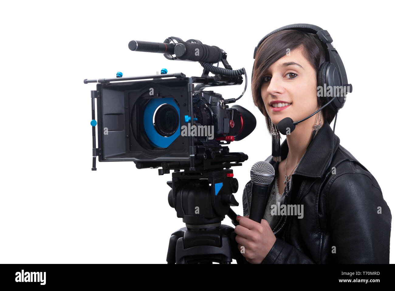 a pretty young woman journalist with microphone in television studio on ...