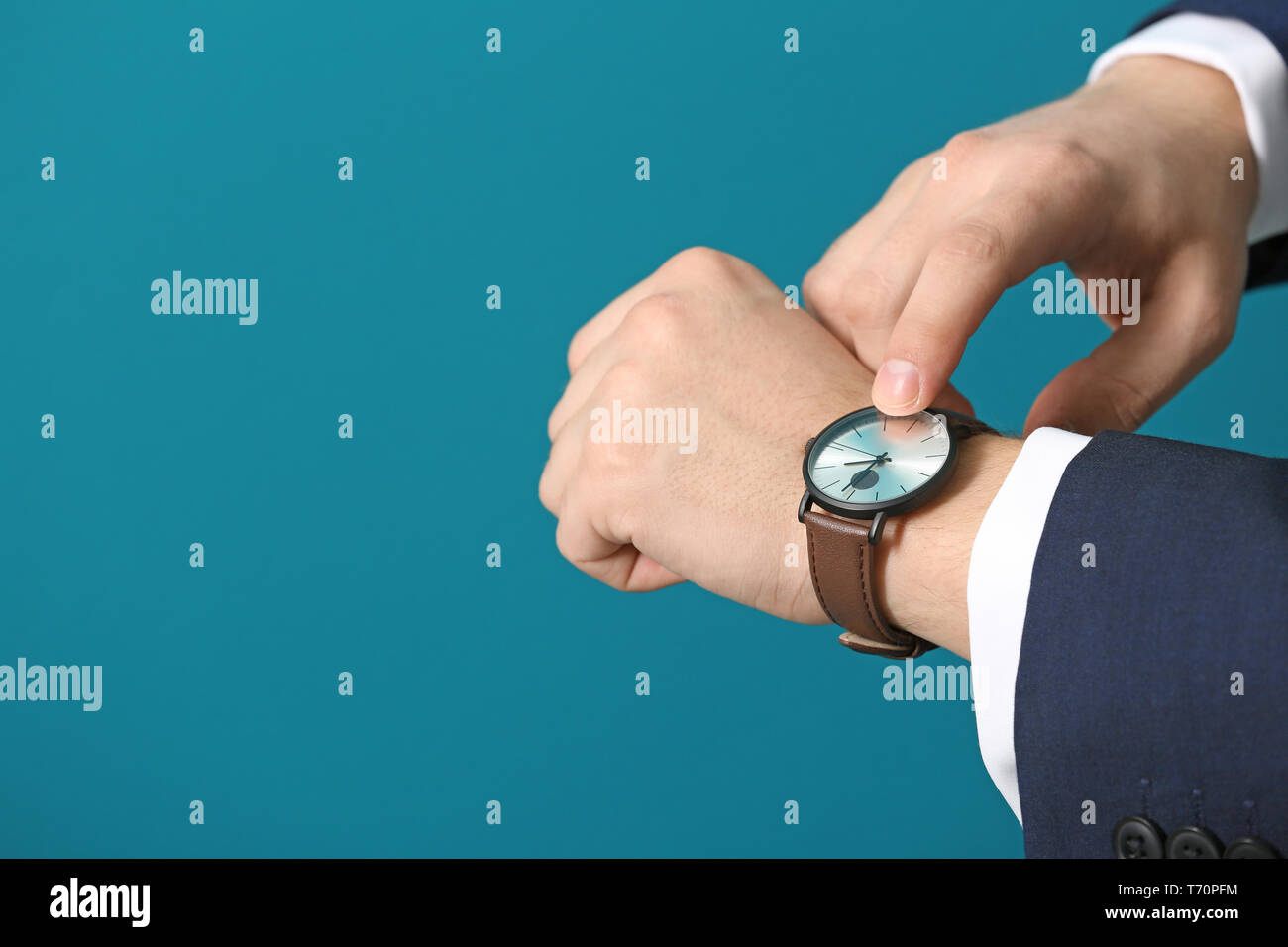 Man looking at his watch on color background, closeup. Time management ...