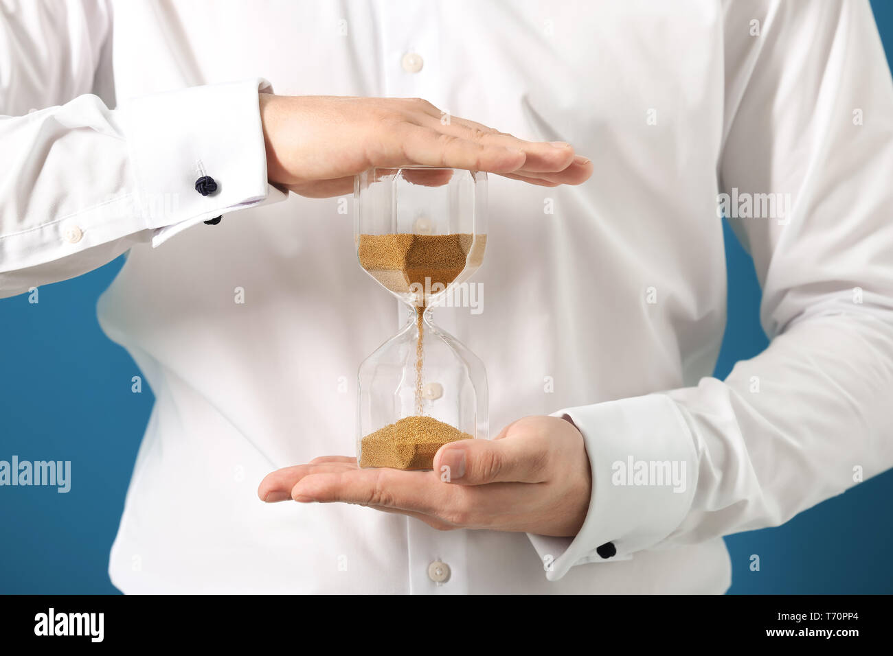 Man holding hourglass, closeup. Time management concept Stock Photo - Alamy