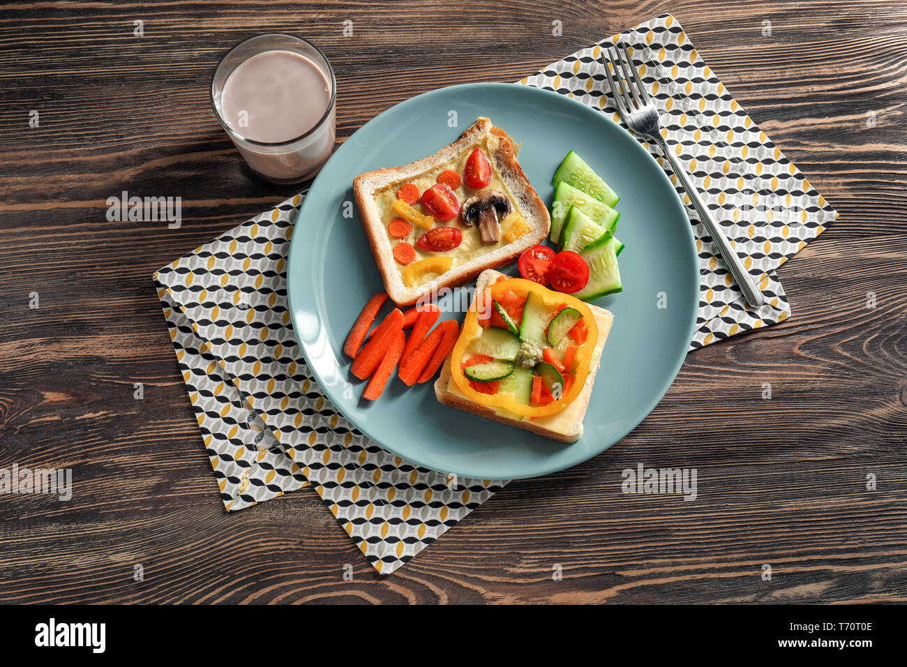 Plate with creative toasts and glass of cocoa drink for children on ...