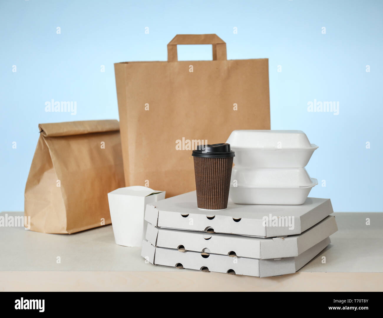 Different packages on table against color background. Food delivery ...
