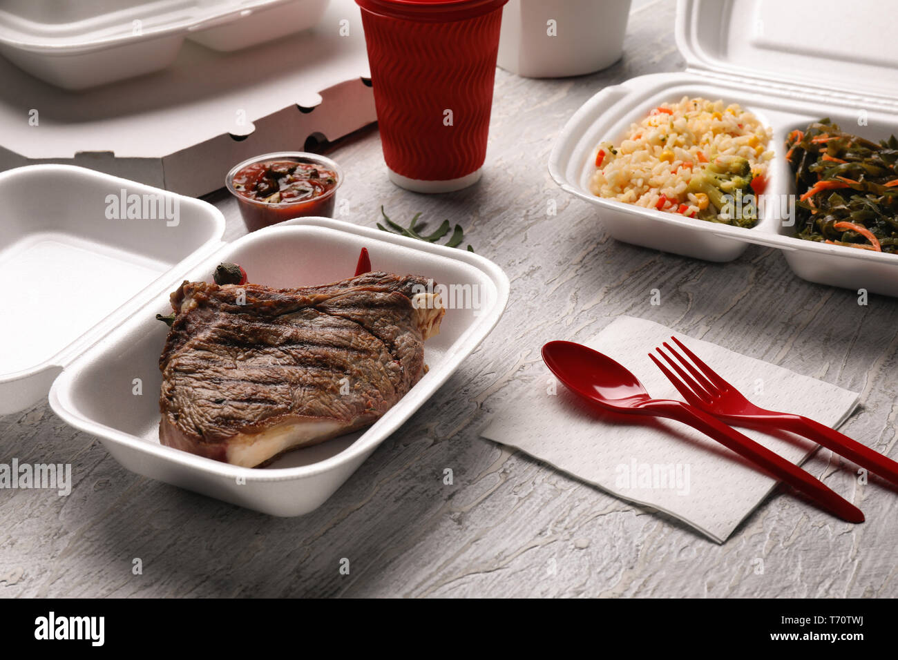 Container with delicious food on wooden table. Delivery service Stock ...