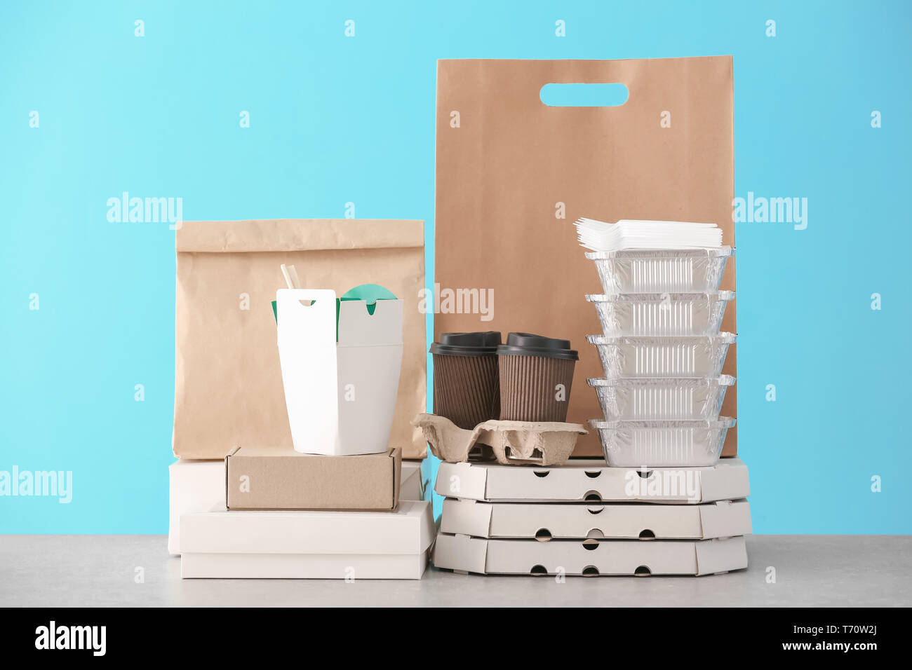 Different packages on table against color background. Food delivery ...