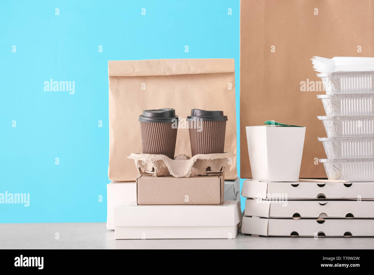 Different packages on table against color background. Food delivery ...