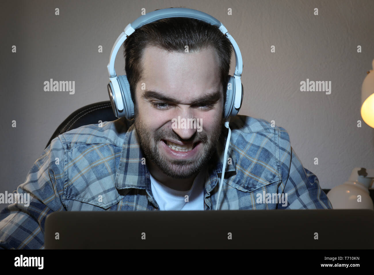 Young man playing video games on laptop at home Stock Photo - Alamy