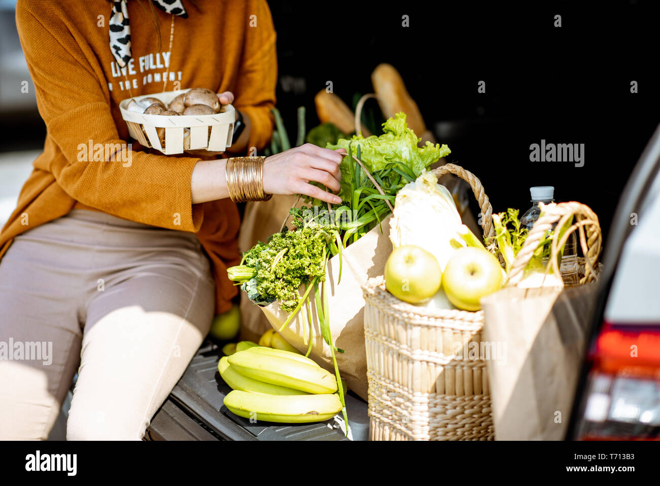 Woman packing fresh food into the shopping bags in the car trunk Stock ...