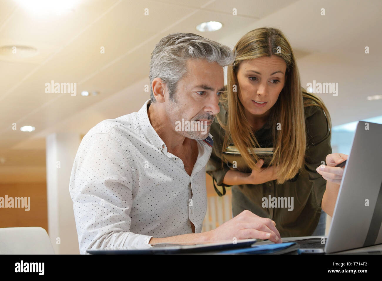 Work colleagues looking at computer in contemporary office Stock Photo ...