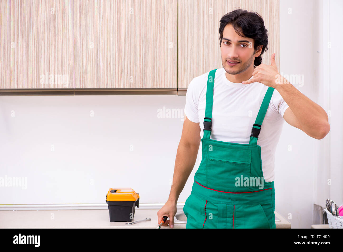 Young plumber installing tap hi-res stock photography and images - Alamy