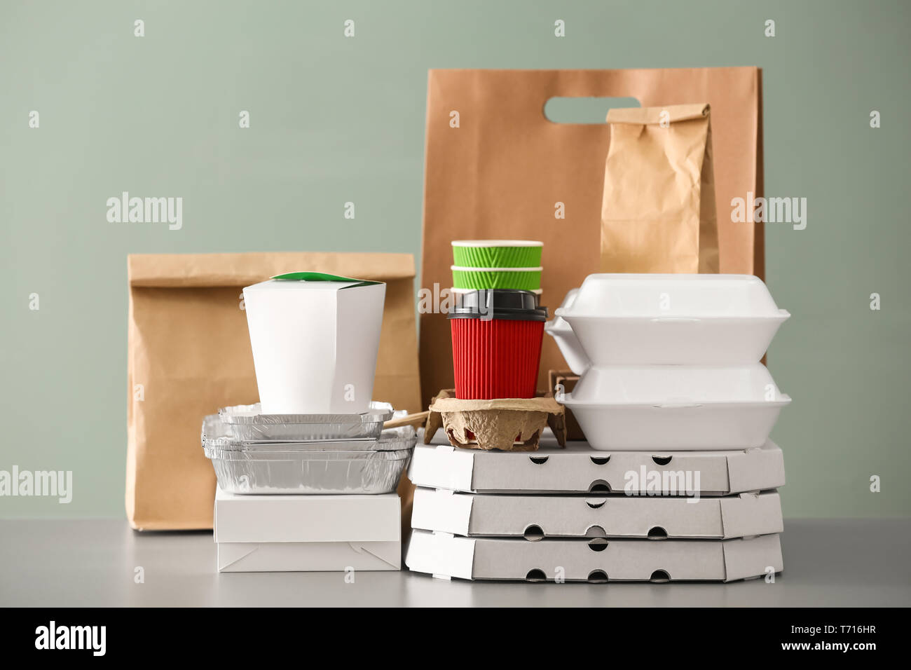 Different packages on table against color background. Food delivery ...