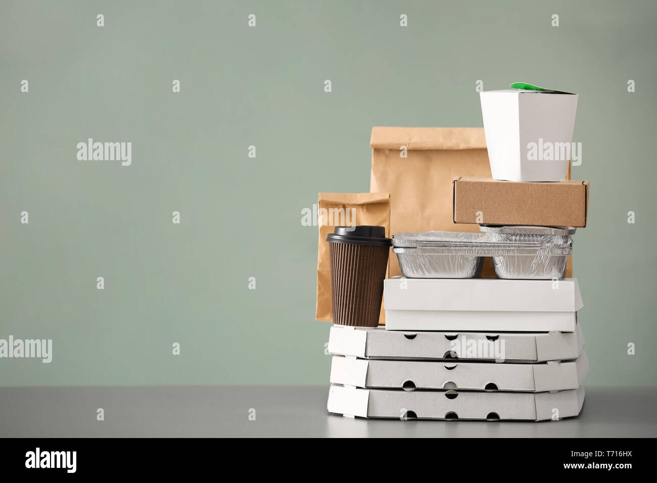 Different packages on table against color background. Food delivery ...