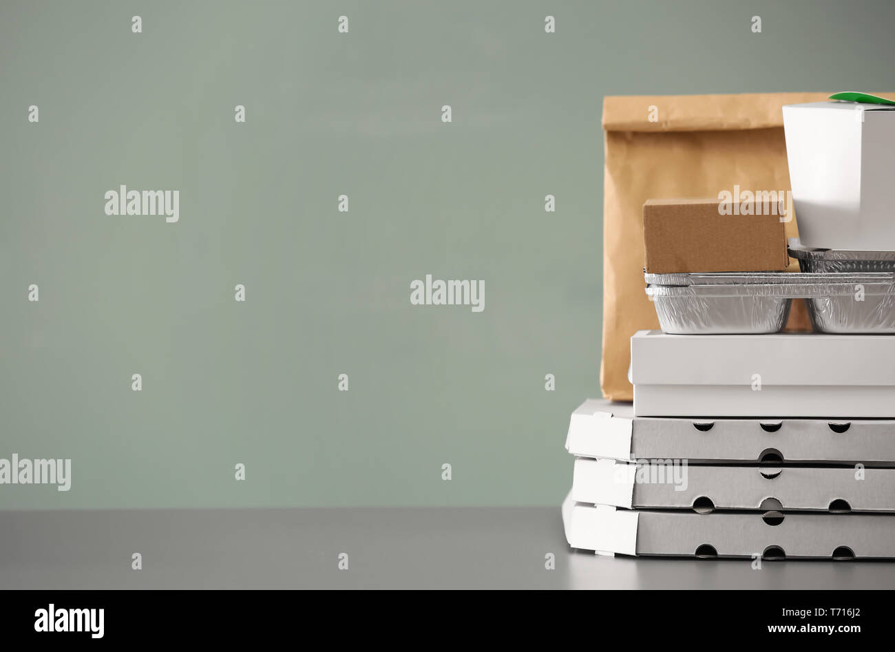 Different packages on table against color background. Food delivery ...