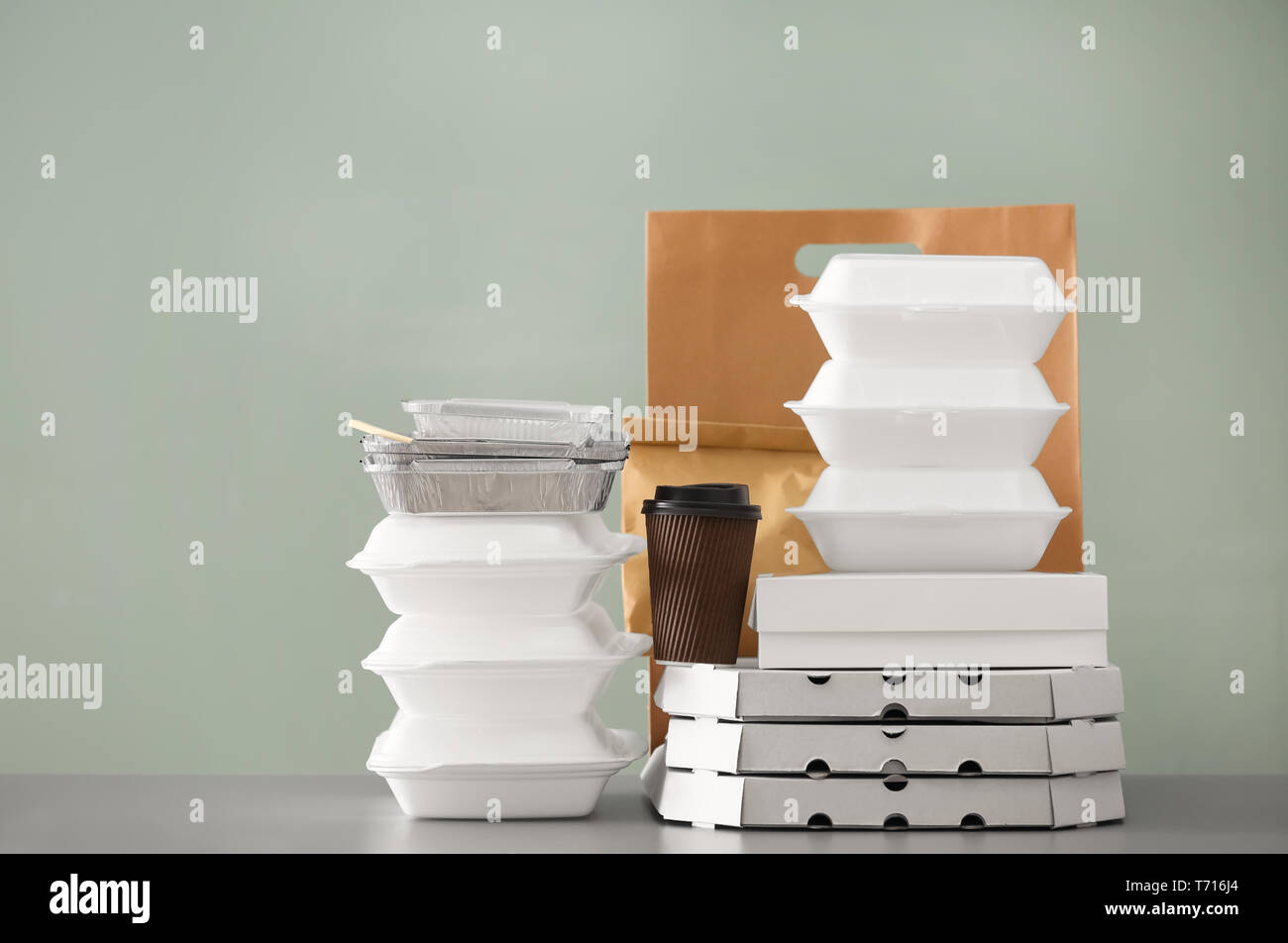 Different packages on table against color background. Food delivery ...