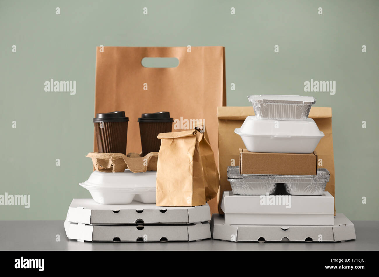 Different packages on table against color background. Food delivery ...