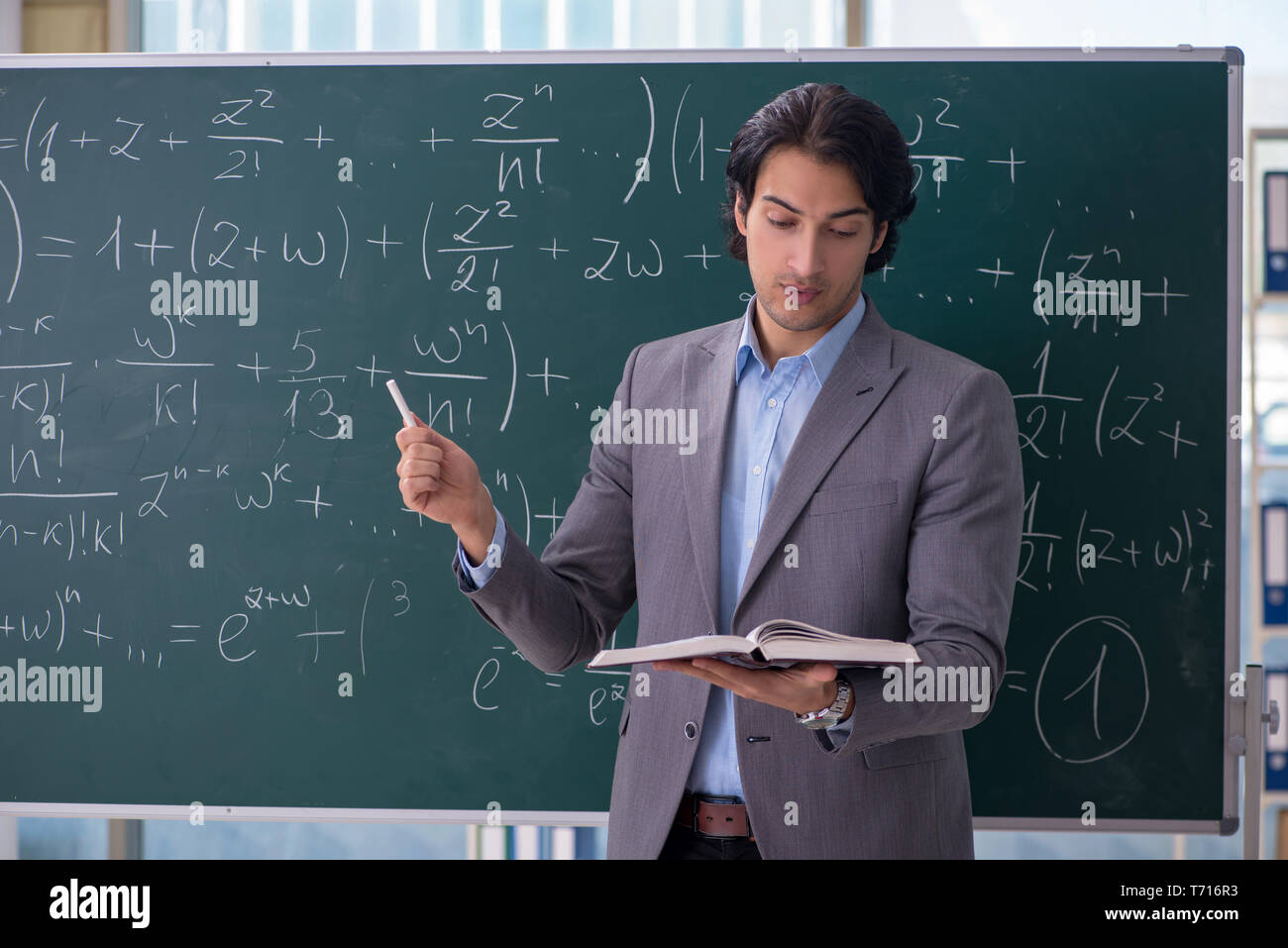 Young handsome math teacher in classroom Stock Photo - Alamy