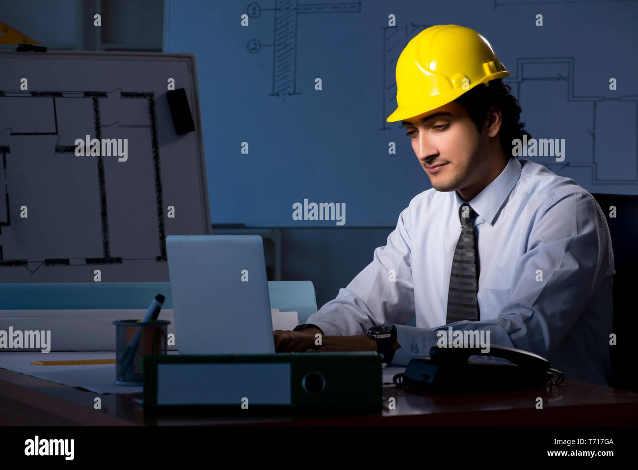 Young construction architect working on project at night Stock Photo ...