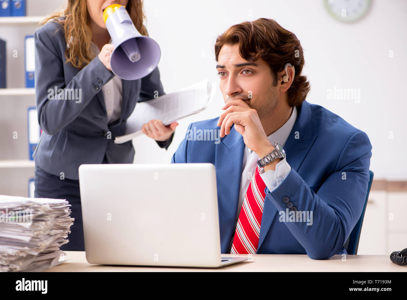 Deaf employee using hearing aid talking to boss Stock Photo - Alamy