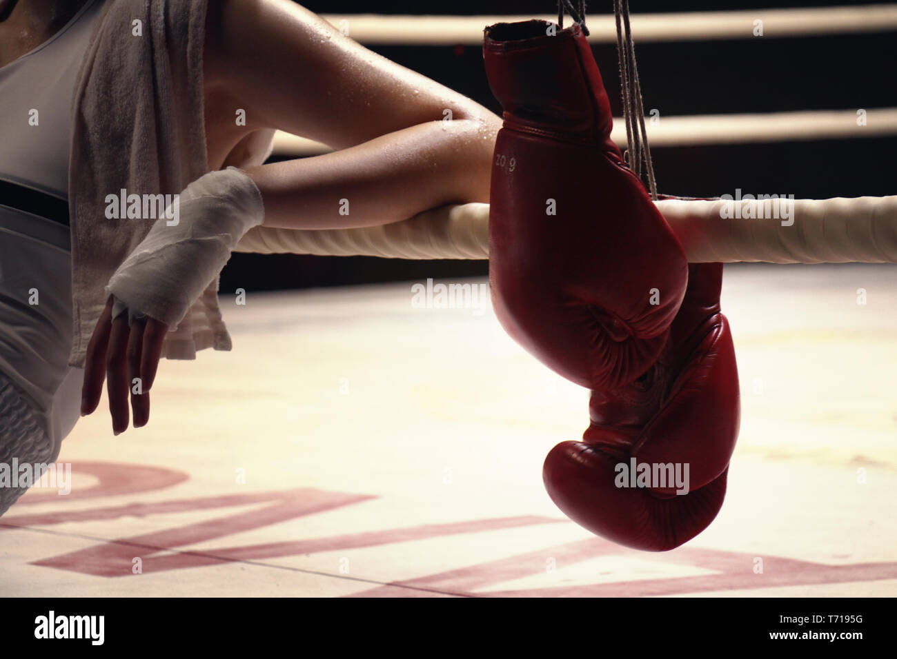 a boxer take a rest after trainig and hanging boxing gloves with the ...