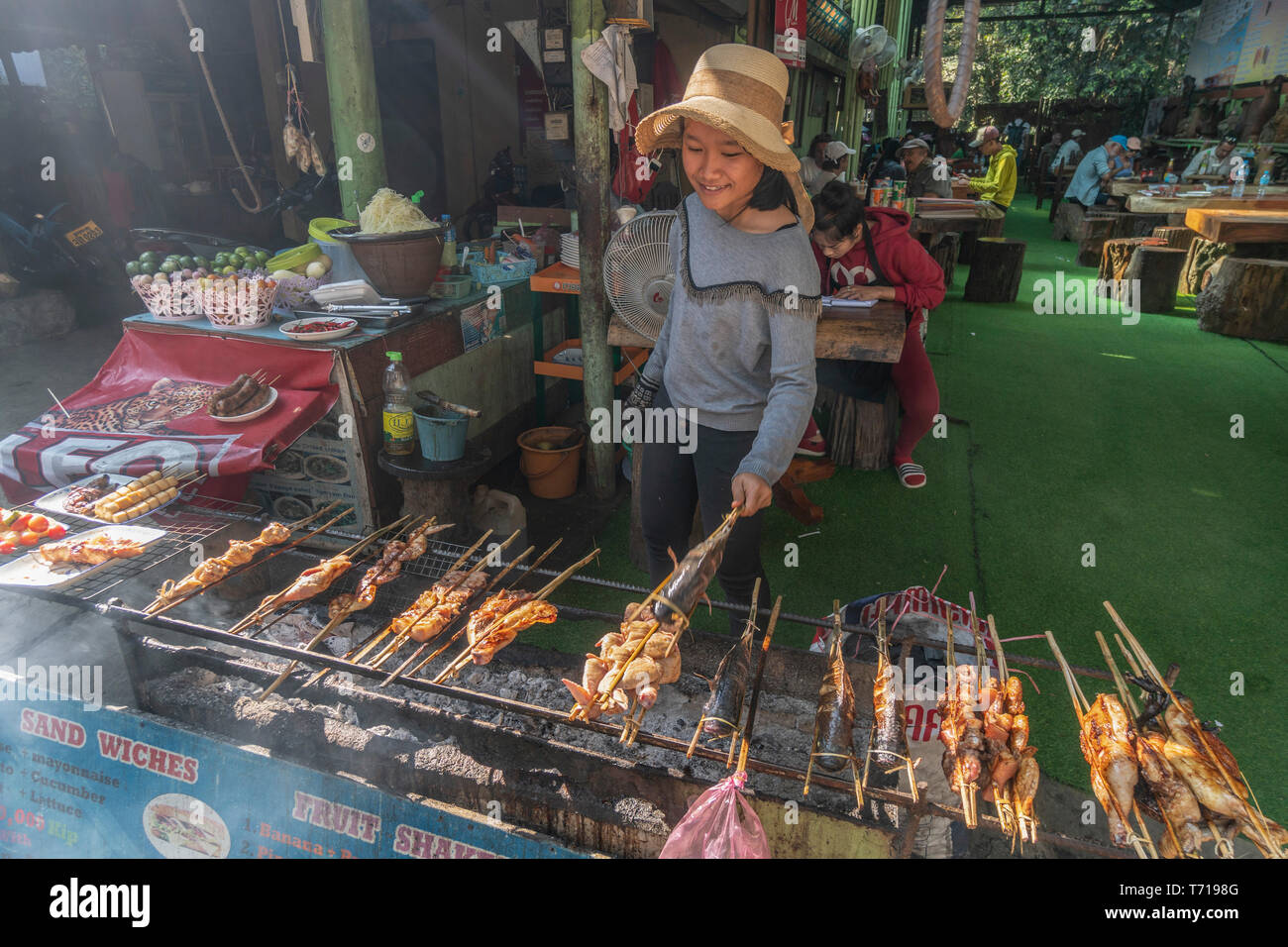 young lao girl at food stall near Kuang Si waterfall , close to Luang ...