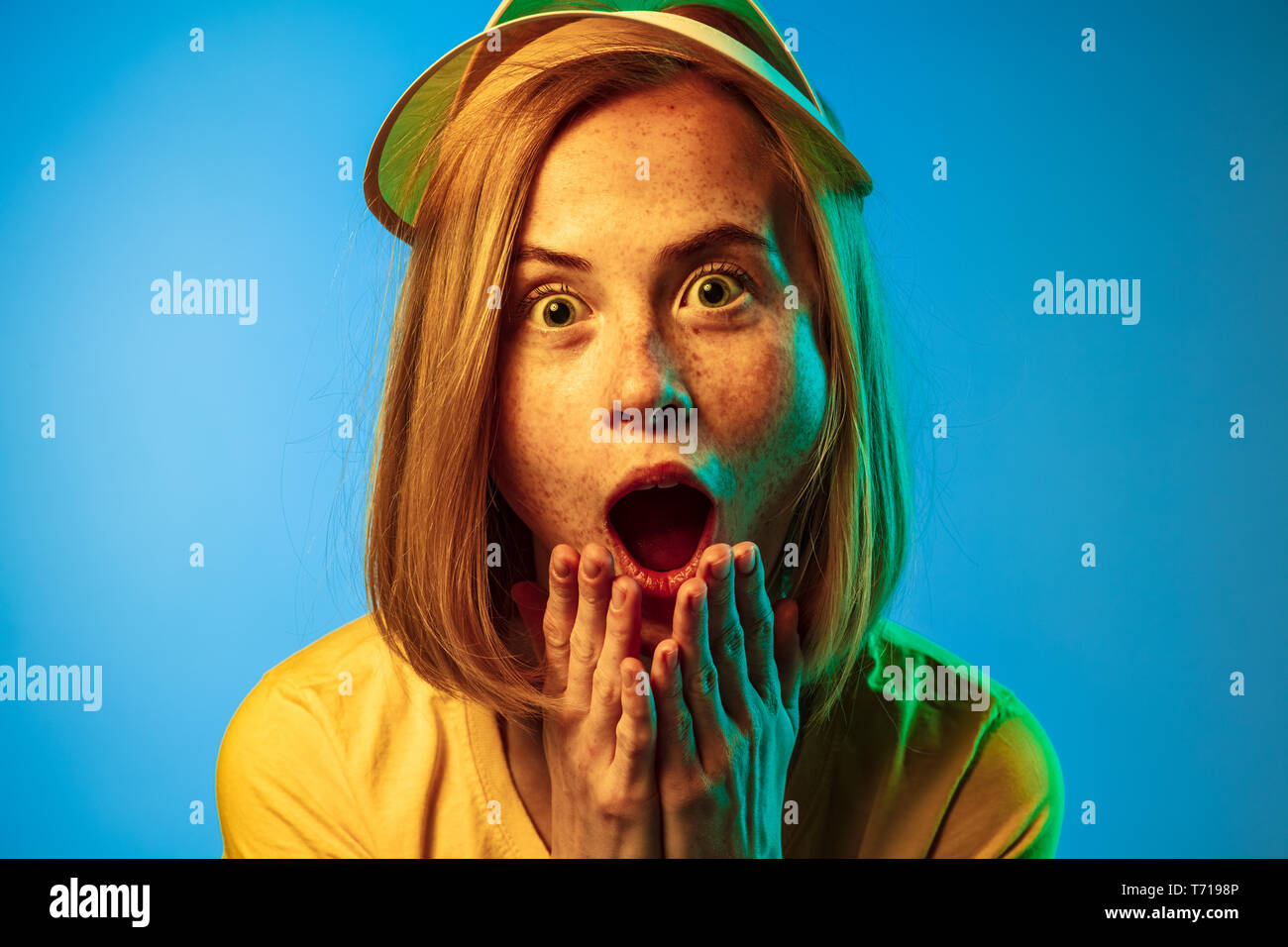 Beautiful female close up portrait isolated on blue neon lights studio ...