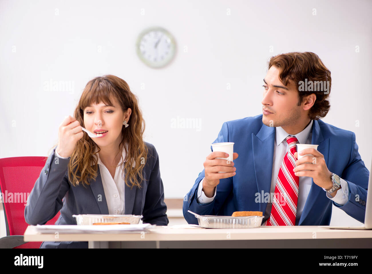 Two colleagues having lunch break at workplace Stock Photo - Alamy