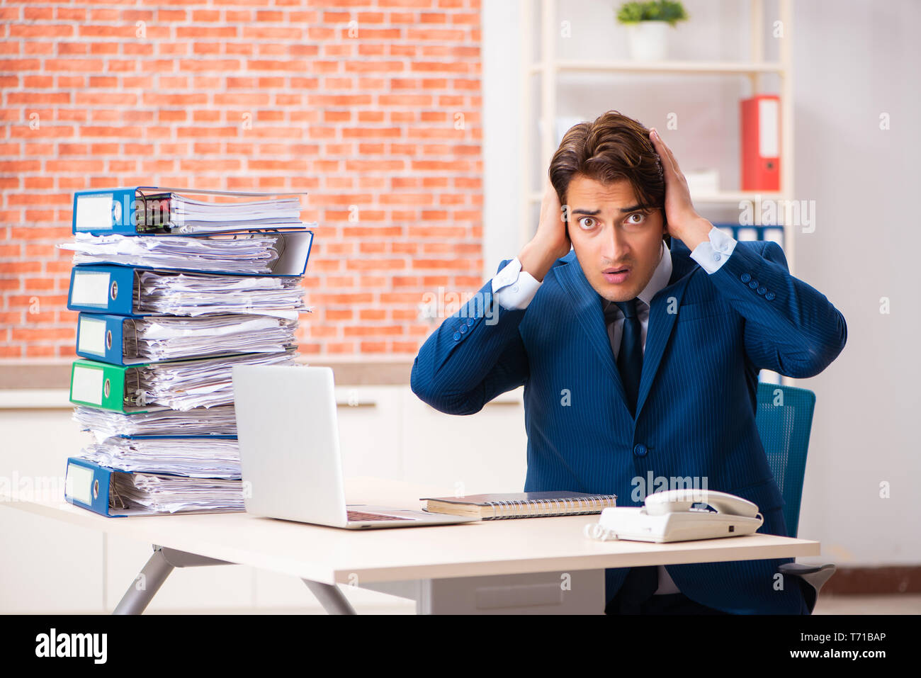 Young elegant man unhappy with too much work Stock Photo - Alamy