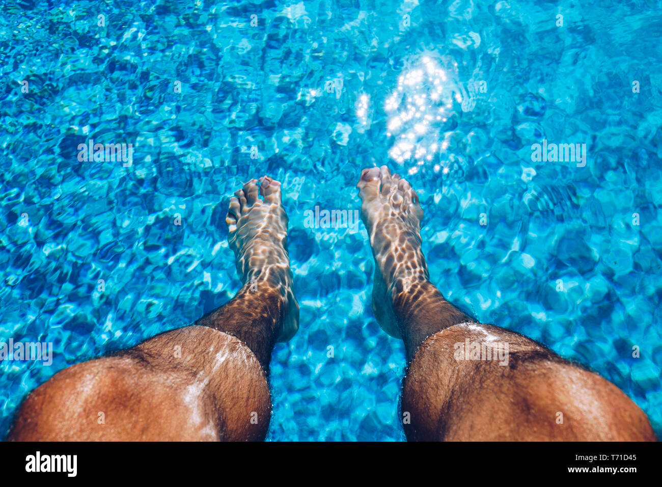 Relaxing at the swimming pool. Man relaxing next to swimming pool. Man ...