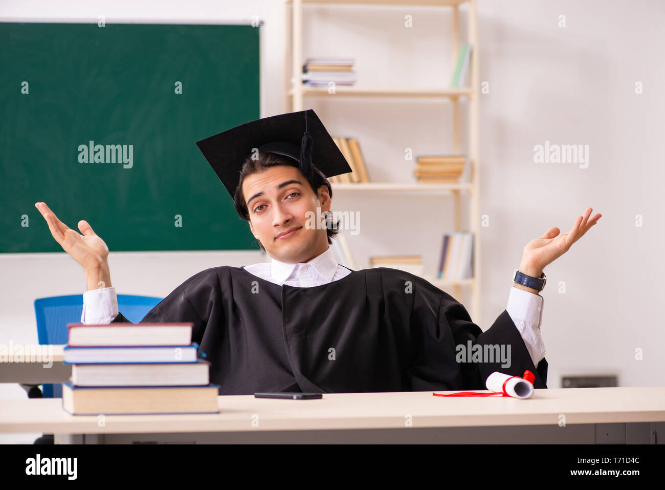 Graduate student in front of green board Stock Photo - Alamy