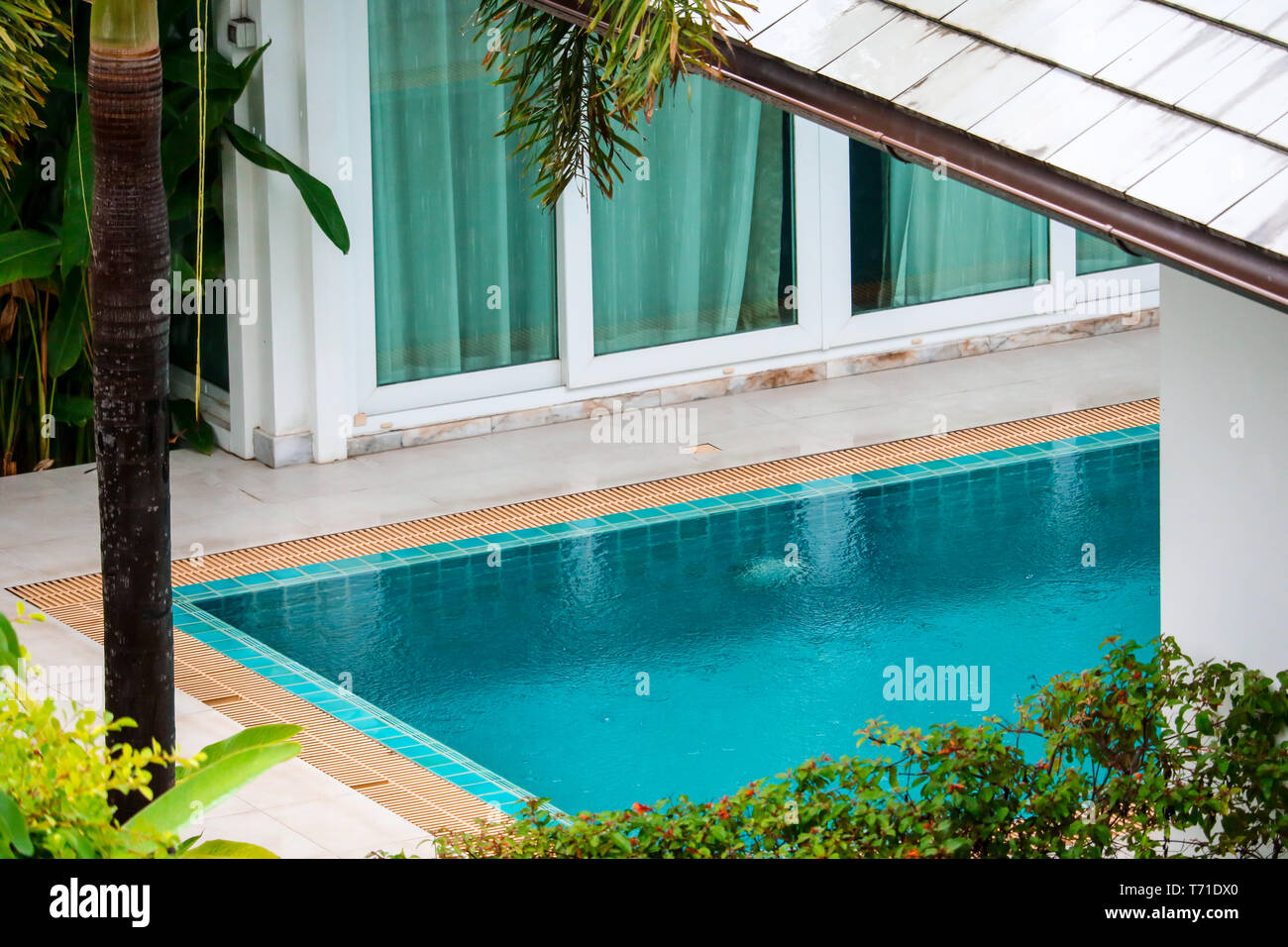 rain fall on swimming pool middle garden in the villa Stock Photo - Alamy